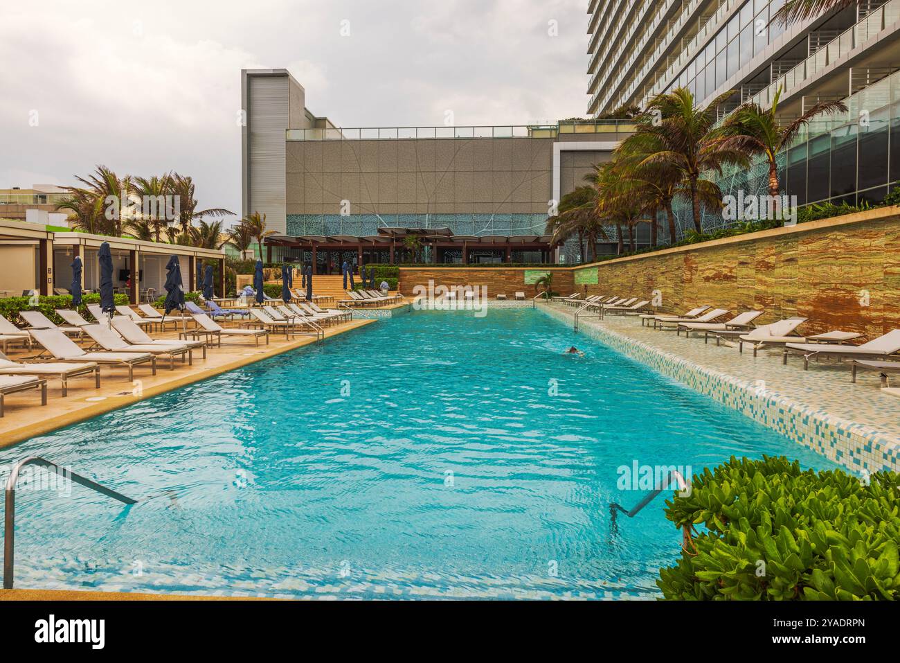 Luxurious hotel outdoor pool with lounge chairs and modern architecture ...