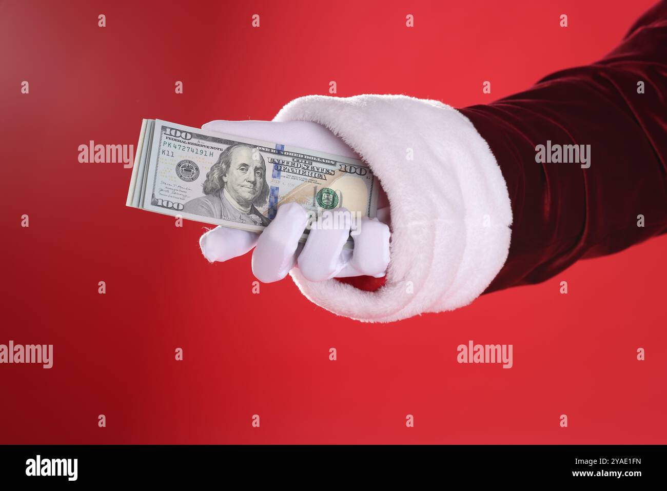 Santa Claus holding dollar banknotes on red background, closeup Stock ...