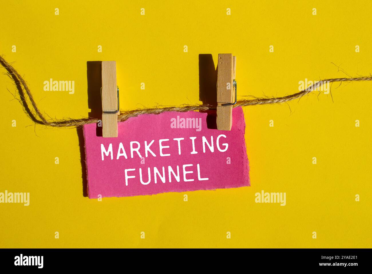Marketing funnel message written on ripped pink paper piece with yellow ...