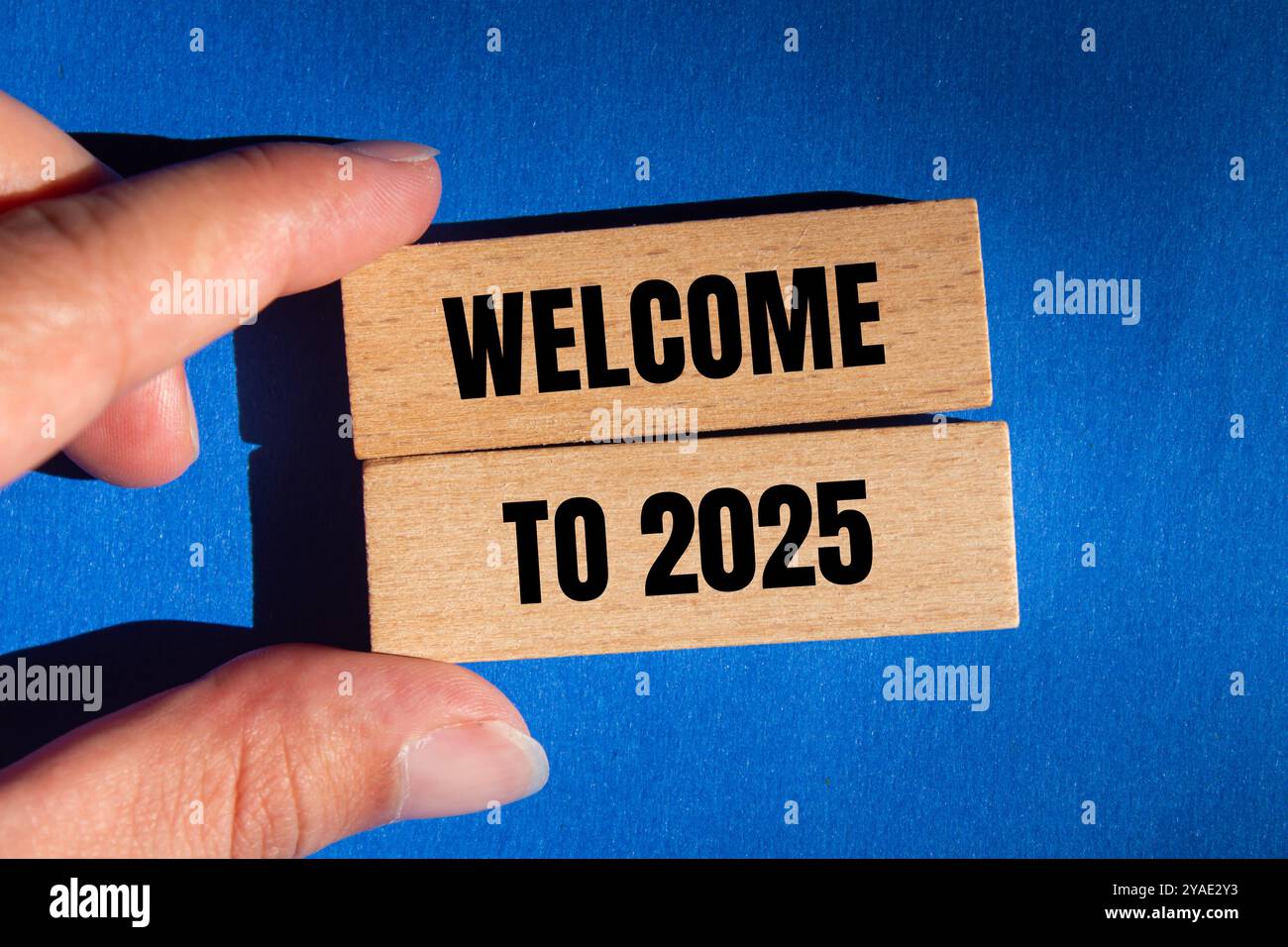 Welcome to 2025 message written on wooden blocks with blue background. Conceptual welcome to ...