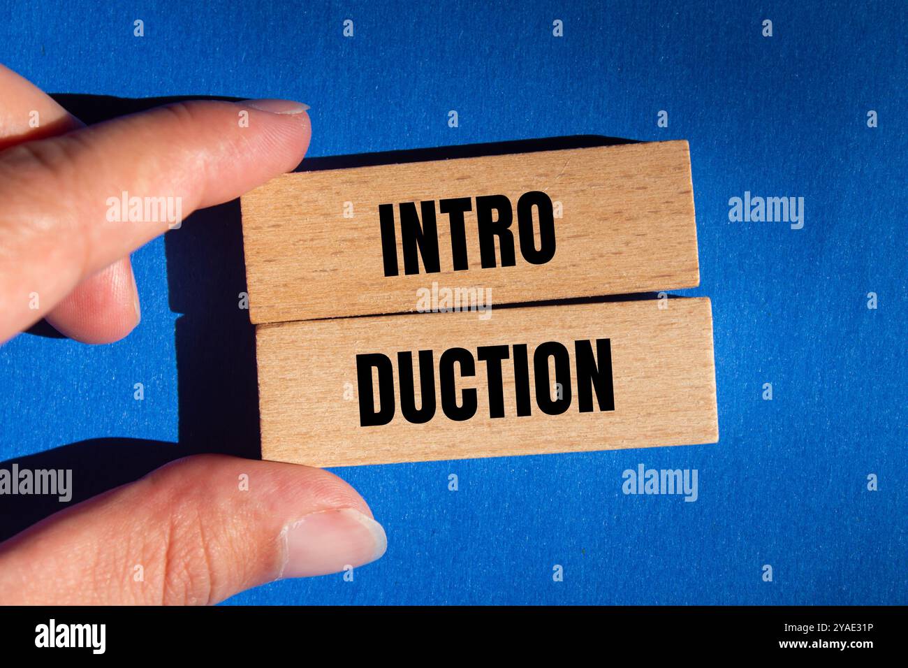Introduction message written on wooden blocks with blue background ...