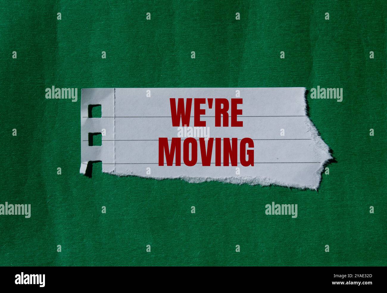 We are moving message written on ripped torn paper with green ...