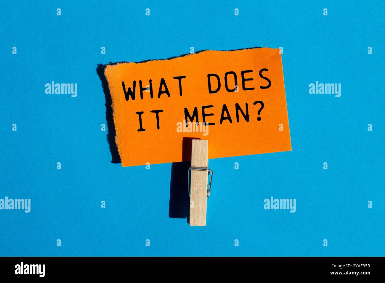 What does it mean question written on ripped torn orange paper on blue ...