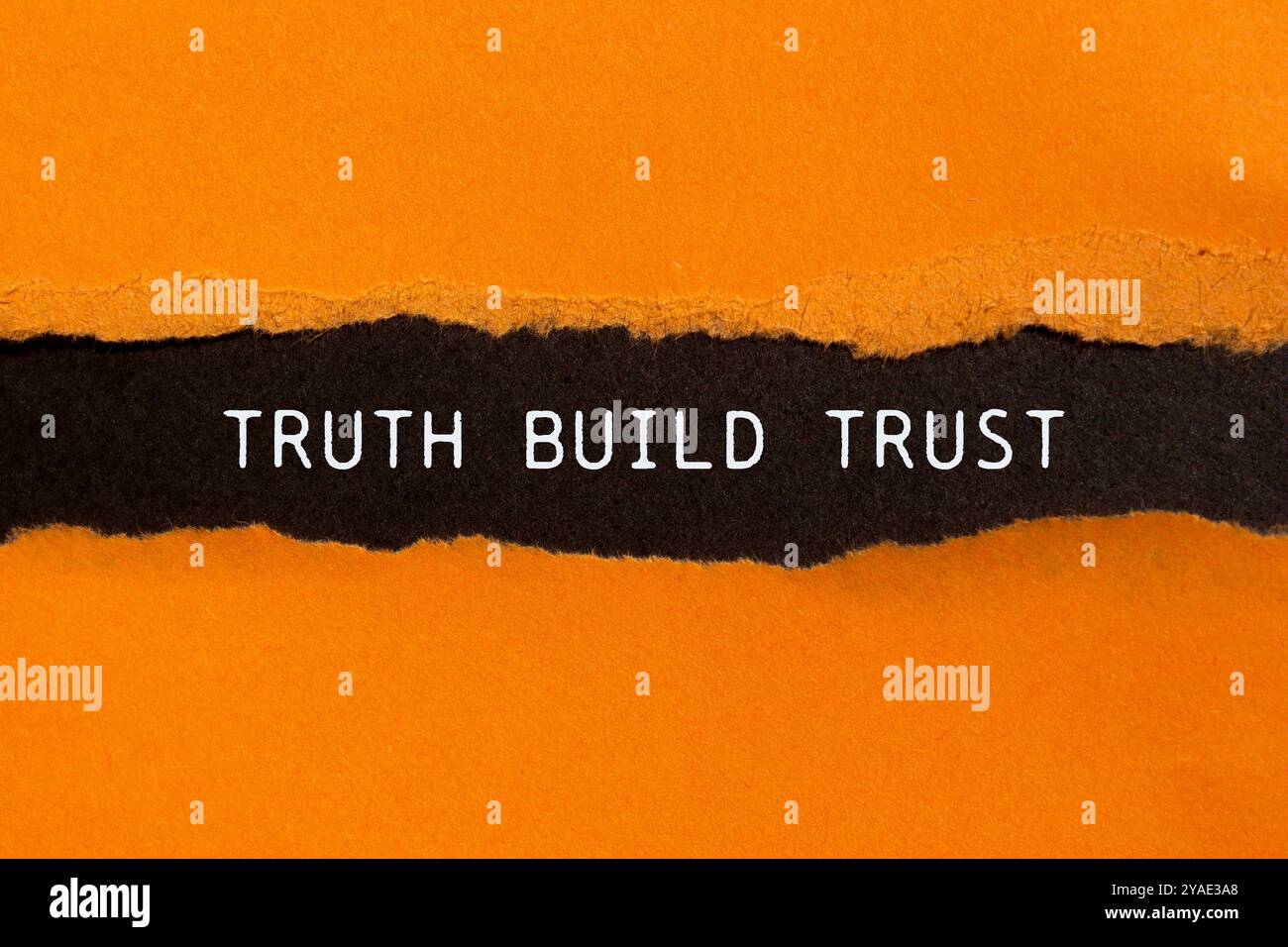 Truth build trust message written on ripped torn orange paper on black ...