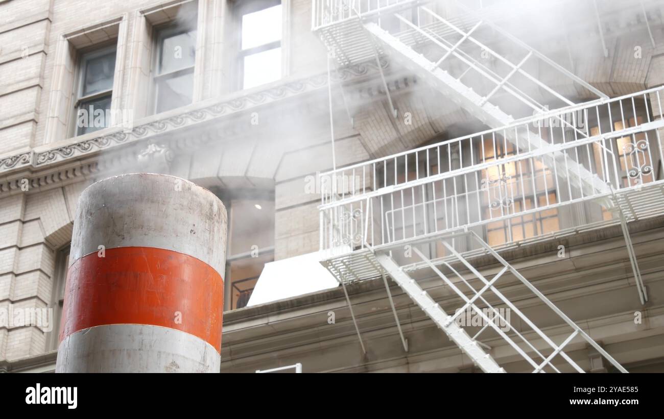 Steam vapor vented on New York City street, orange vapour tube stack ...