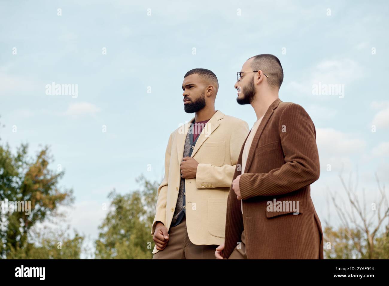 Two male models showcase trendy autumn outfits while standing ...