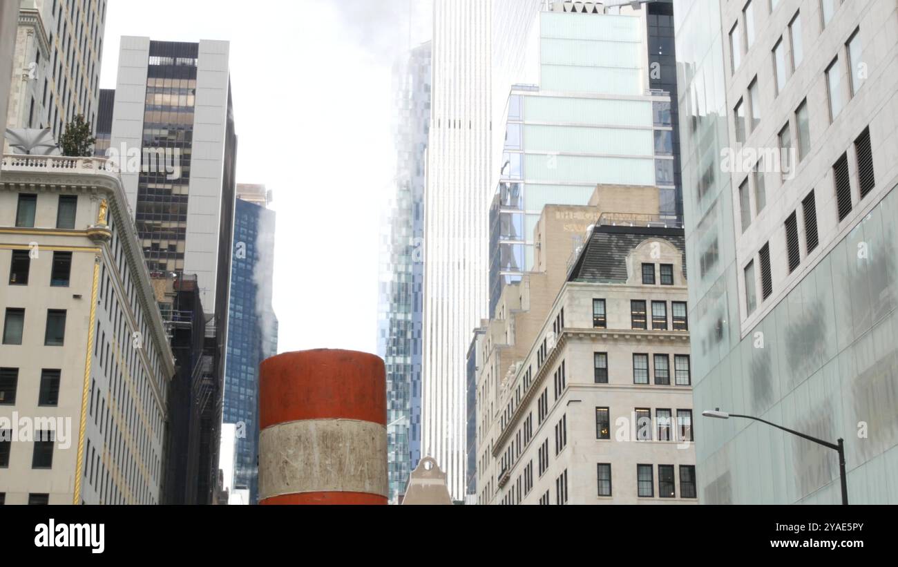 Steam vapor vented on New York City street, orange vapour tube stack ...
