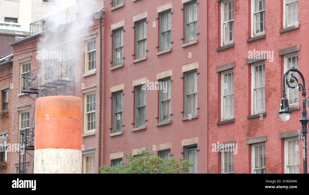 Steam vapor vented on New York City street, orange vapour tube stack ...