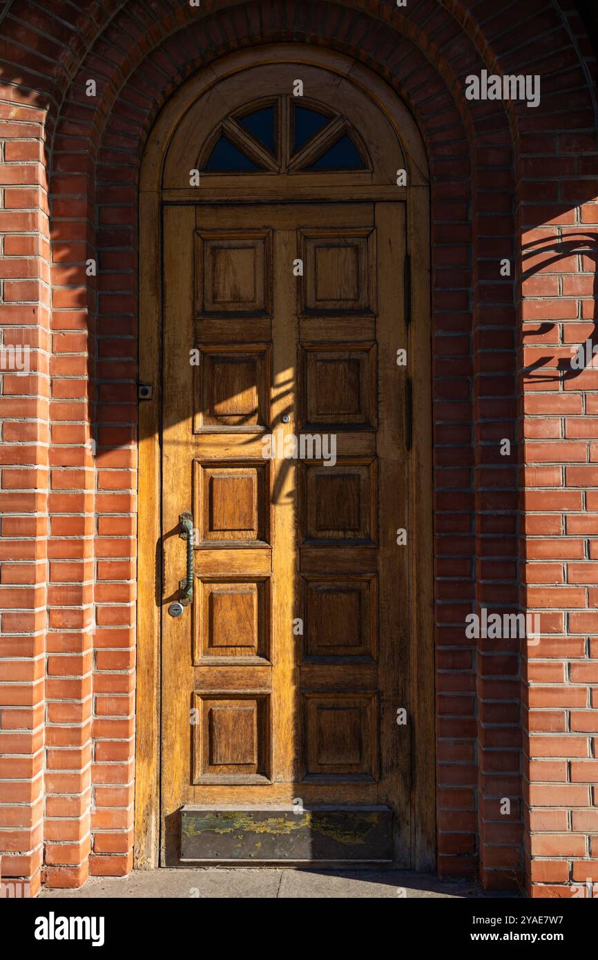 A tall, narrow, old, wooden door. Entrance to the brick building Stock ...