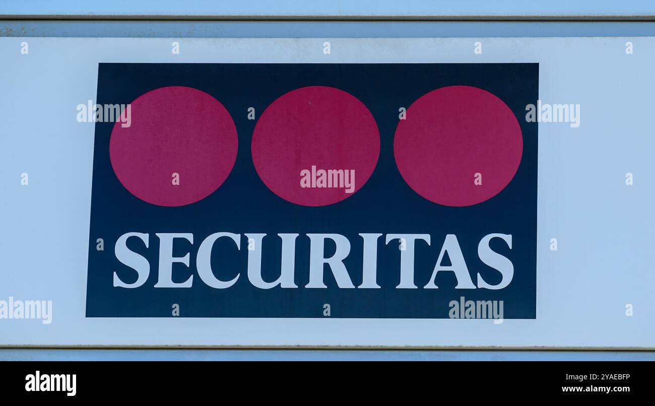 The iconic Securitas logo, featuring three red circles and bold text, stands out against a clear ...