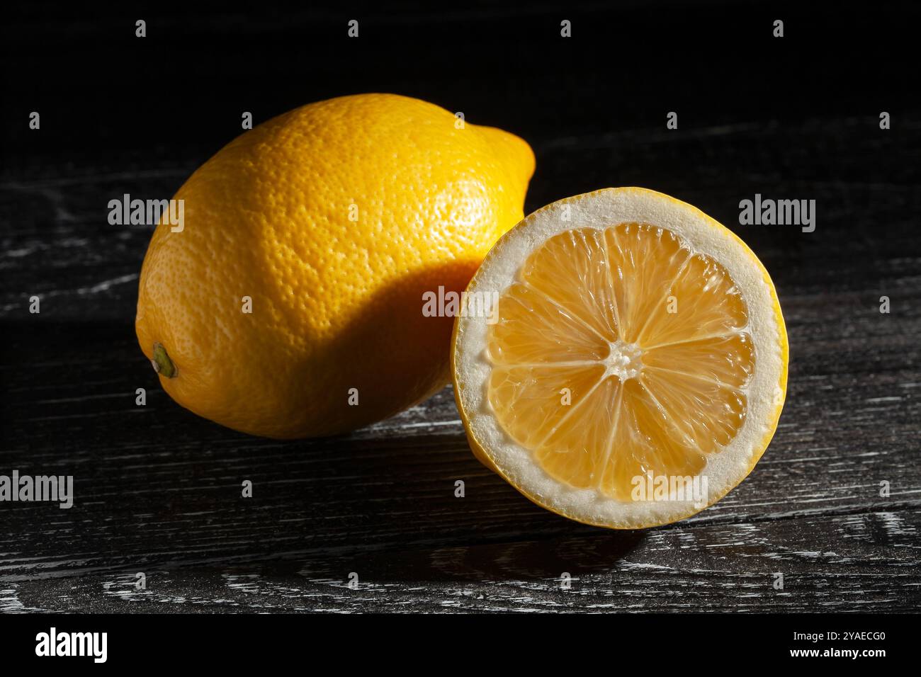 sliced lemon on black wood background Stock Photo - Alamy