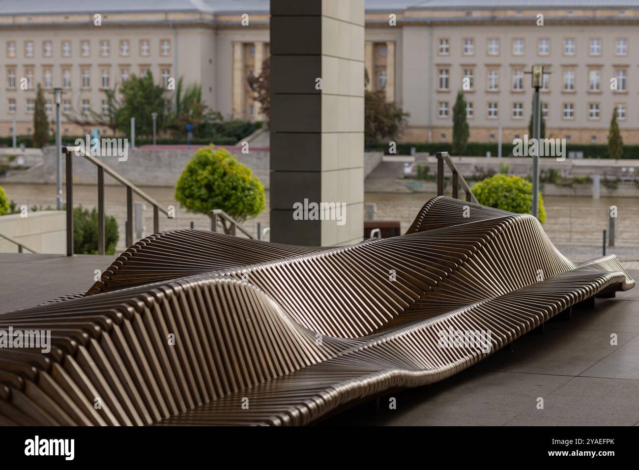 Modern artistic wooden bench with wave-like design placed in a ...
