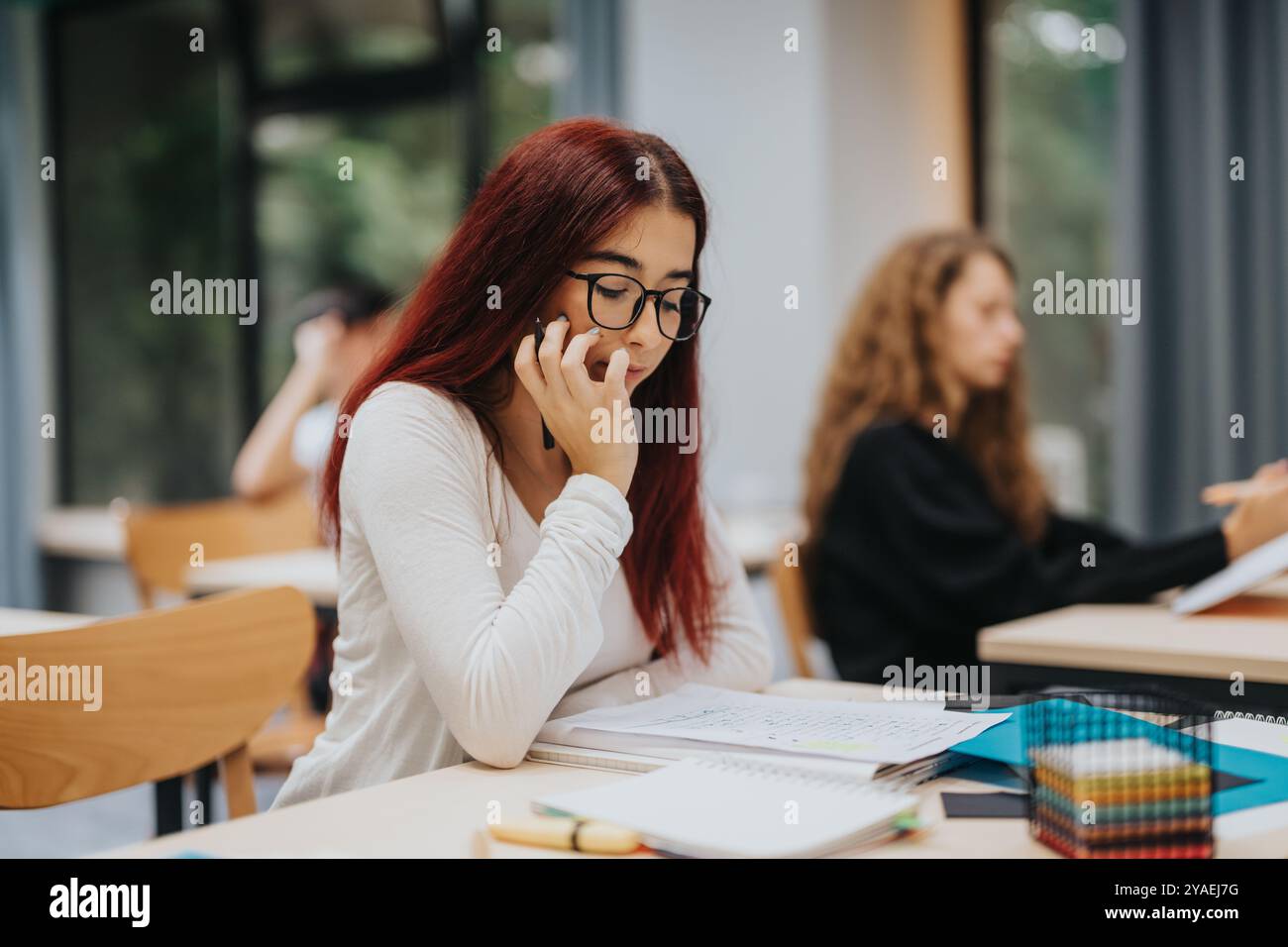 Focused students studying diligently in a modern classroom setting ...