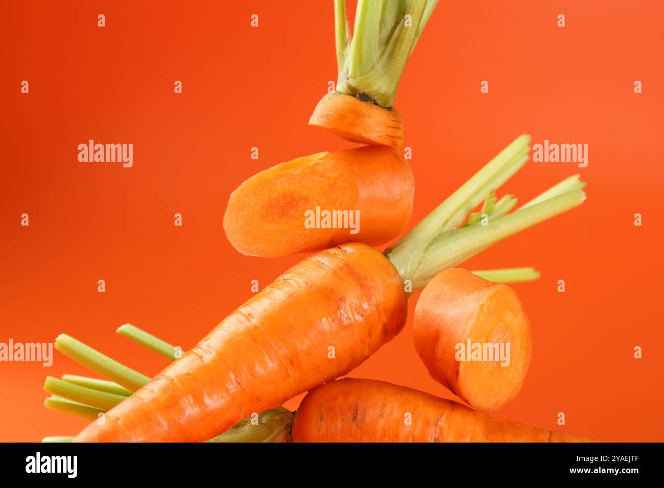Whole and cut fresh carrots on orange background, closeup Stock Photo ...