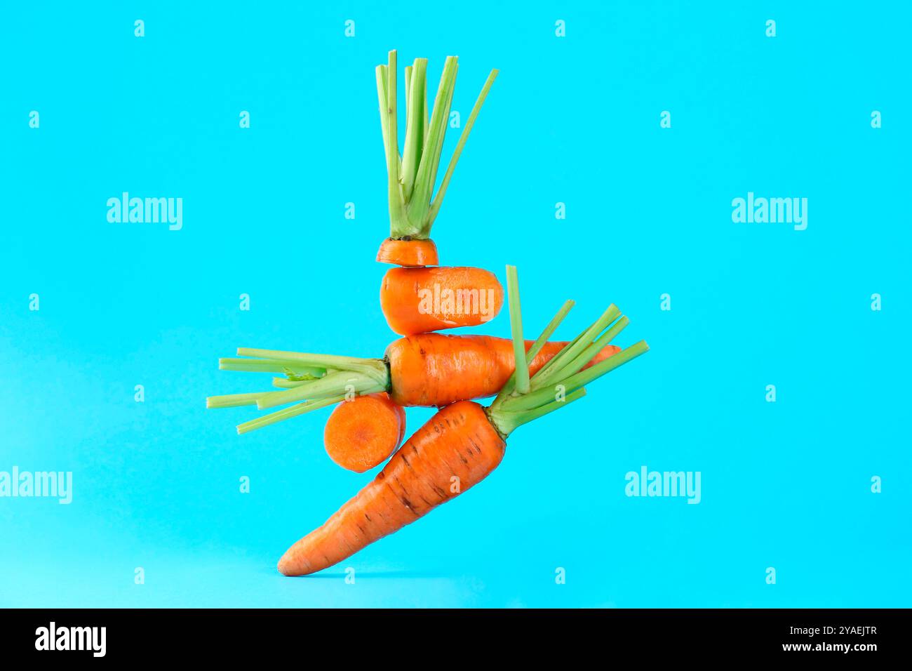 Whole and cut fresh carrots on light blue background Stock Photo - Alamy