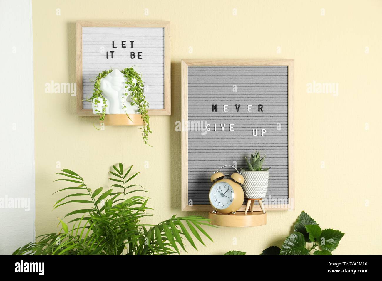 Letter boards with phrases Let It Be, Never Give Up, alarm clock and ...