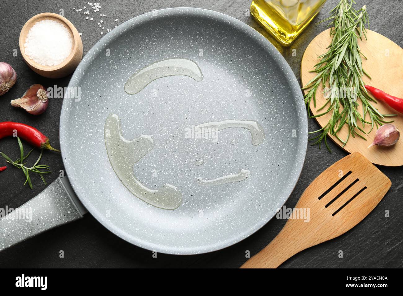 Frying pan with cooking oil and products on dark textured table, flat ...
