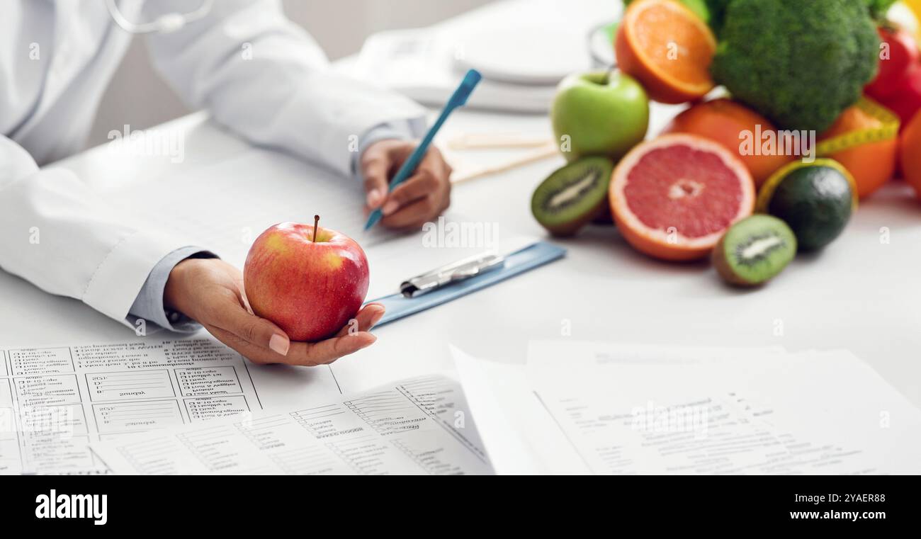 Doctor giving apple to afro woman patient during session Stock Photo ...