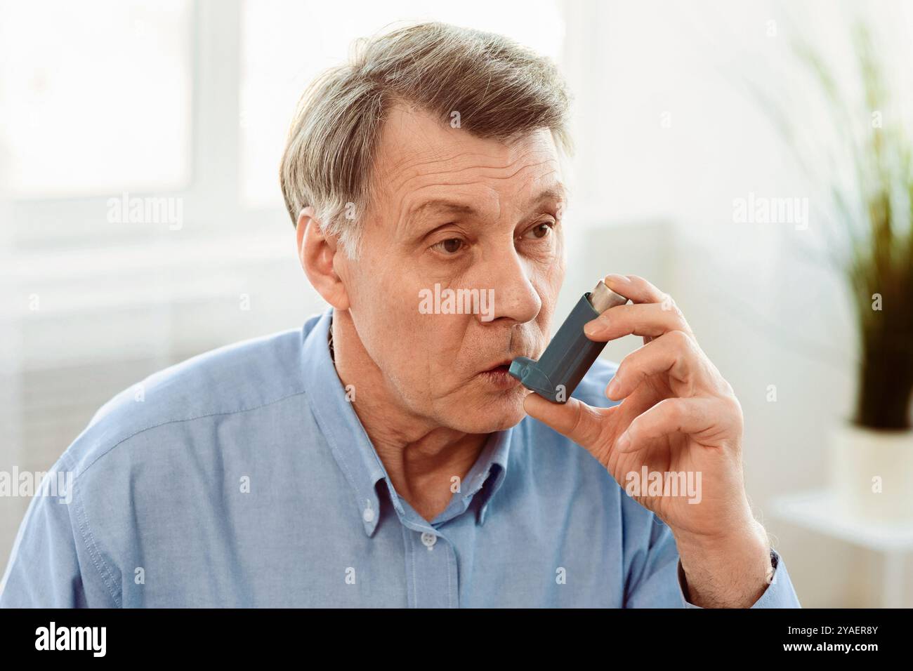 Elderly man using asthma inhaler for allergies Stock Photo - Alamy
