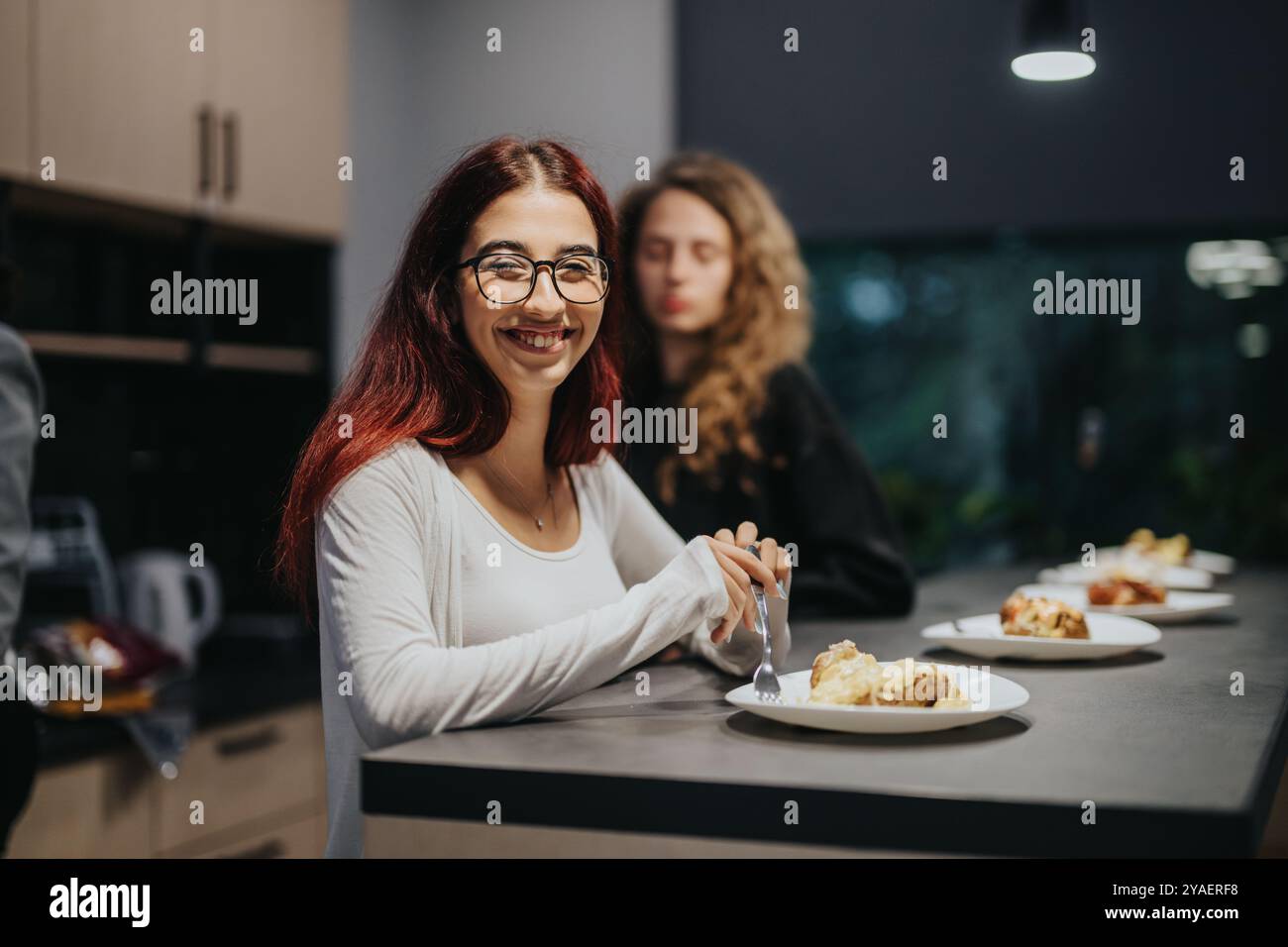 High school students enjoying a meal together in the kitchen Stock ...