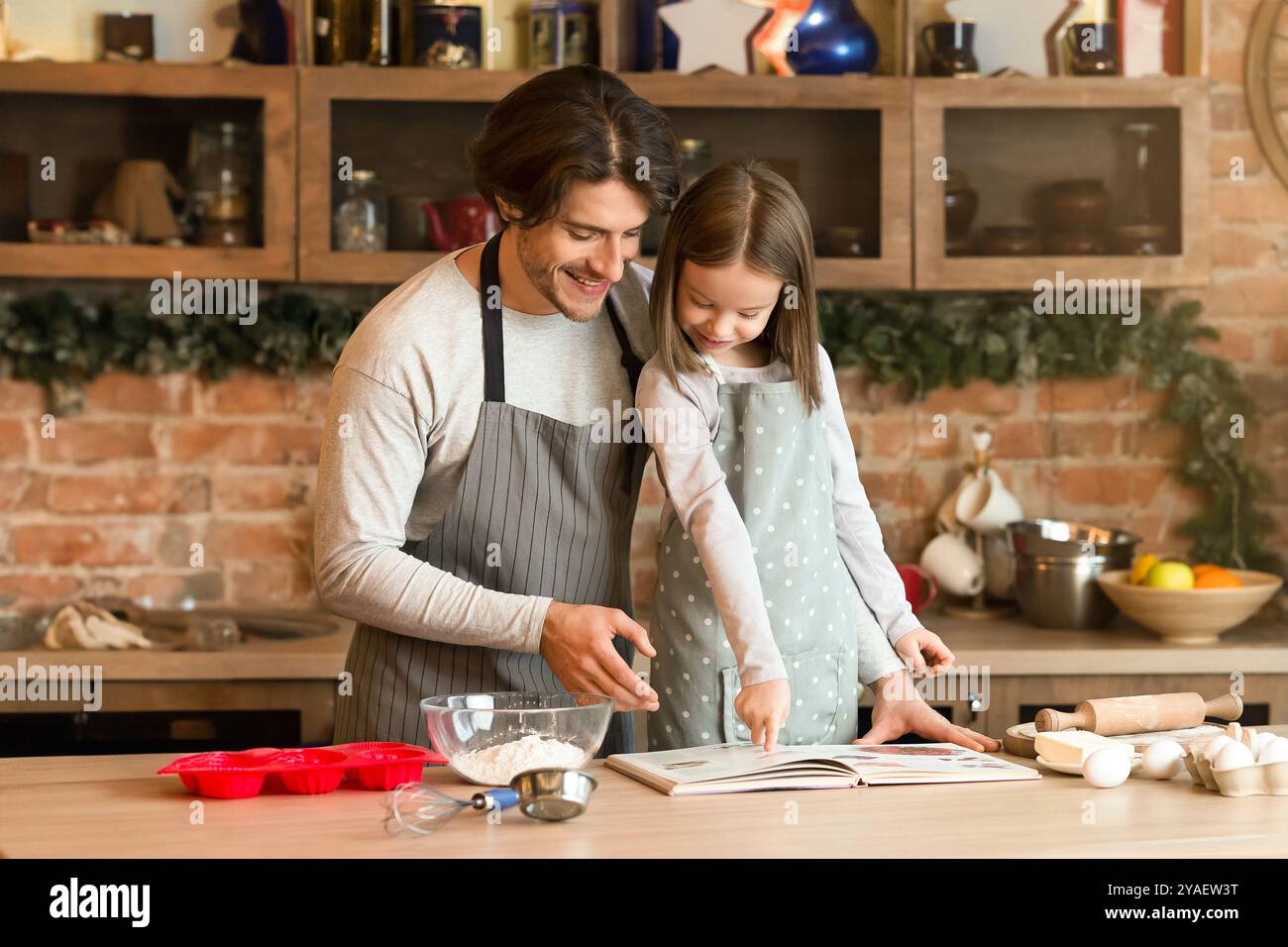 Dad and daughter cooking pastry together, checking recipe in coolinary ...