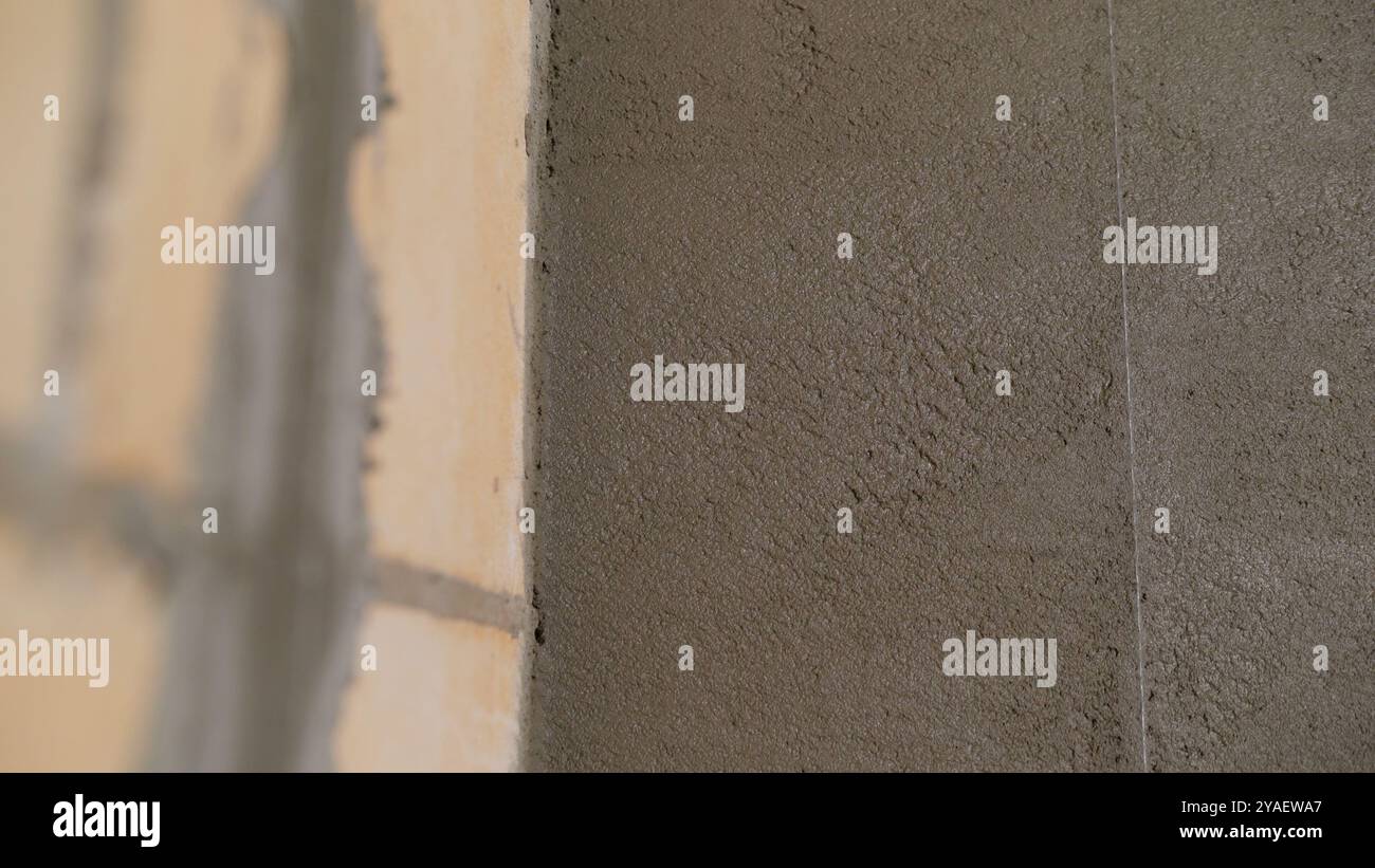 Construction worker applying plaster on a brick wall using a spatula ...