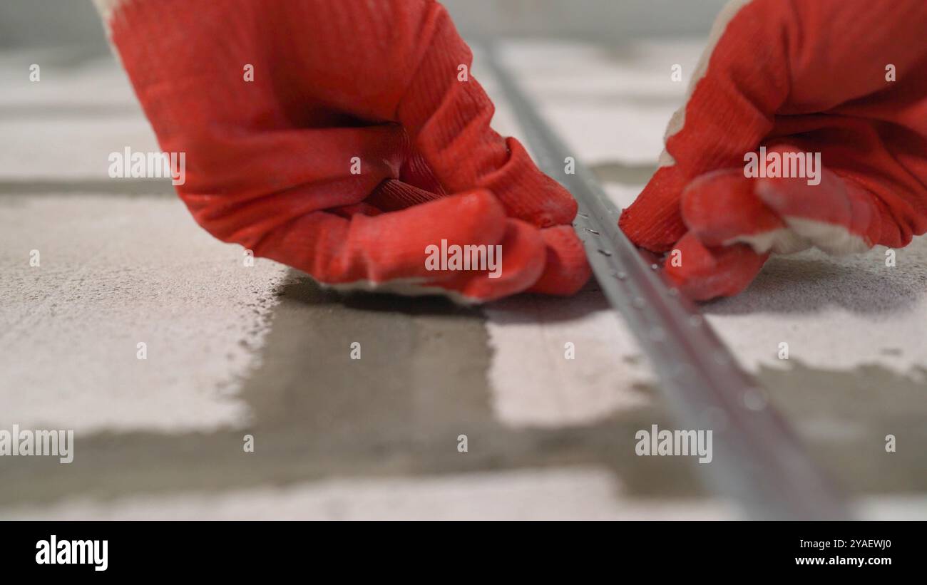 Construction worker installing metal lath on wall using gypsum plaster ...