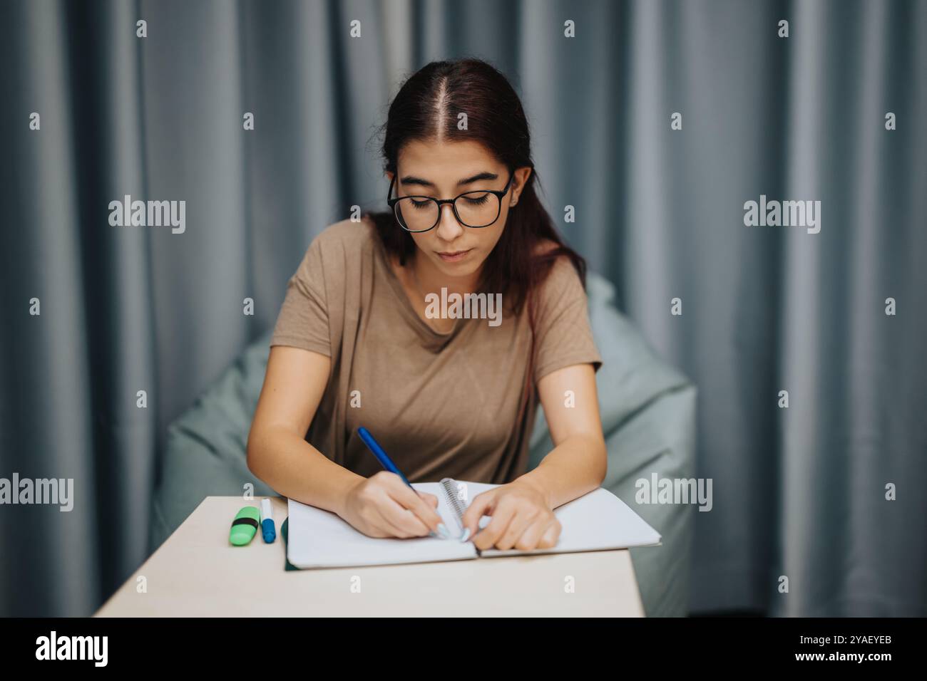 Focused high school student writing notes in study environment Stock ...