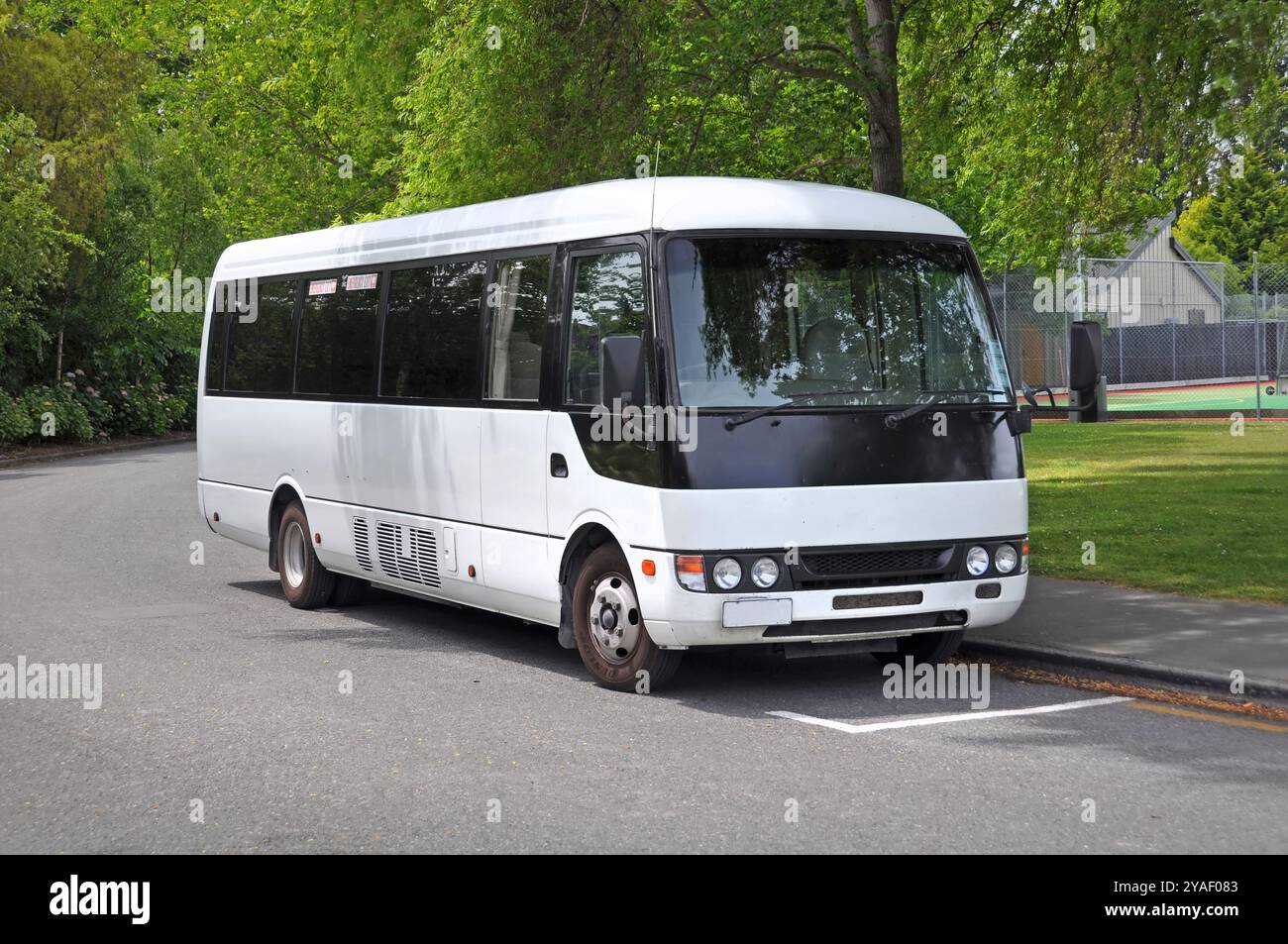 A small white tour coach, bus or mini-van used to transport passengers ...