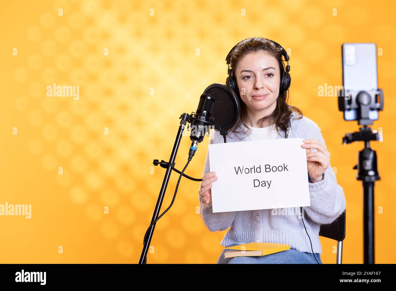 Smiling woman filming promotional video for world book day, isolated ...