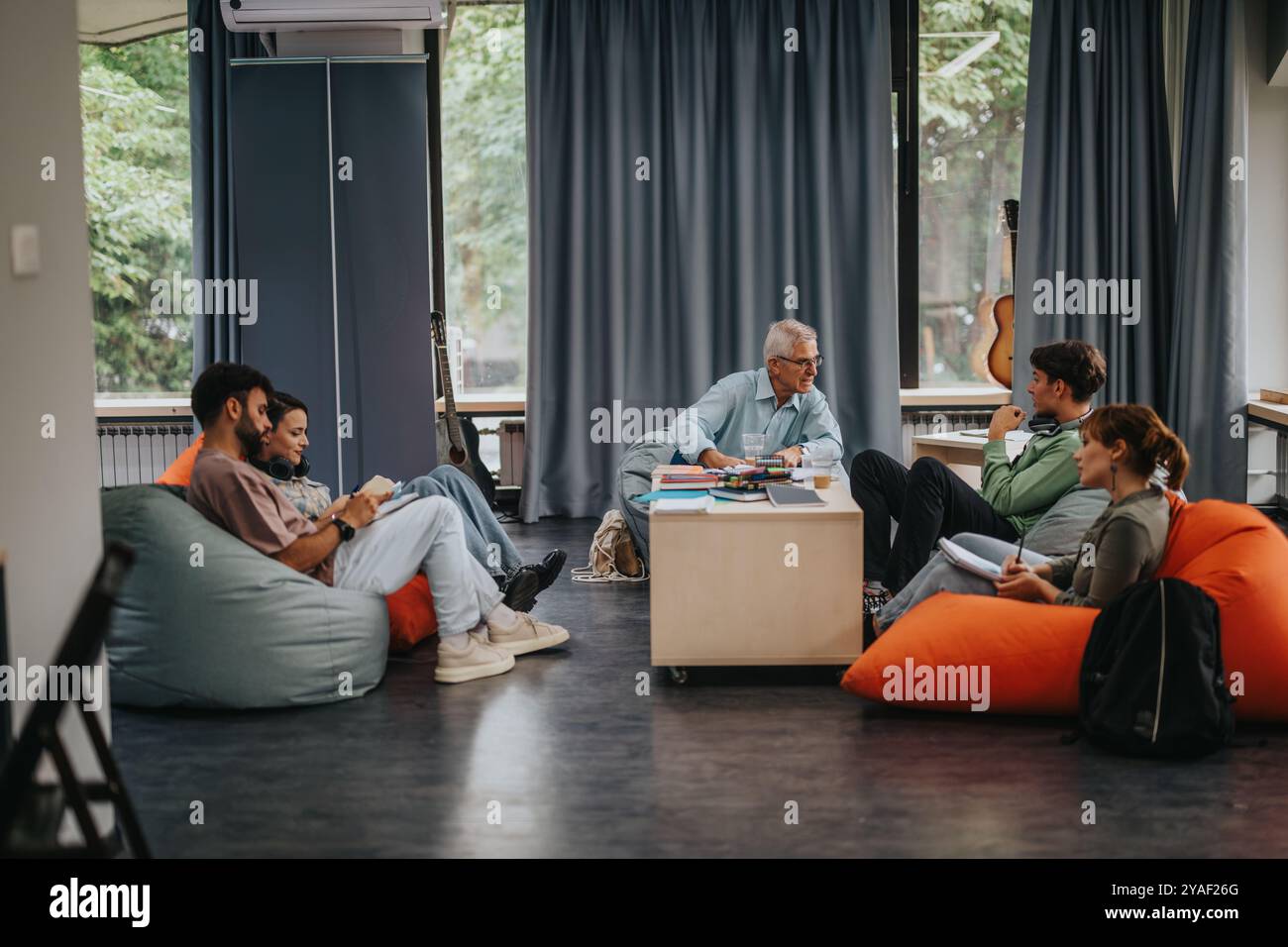 Professor engages with students during relaxed indoor study session ...