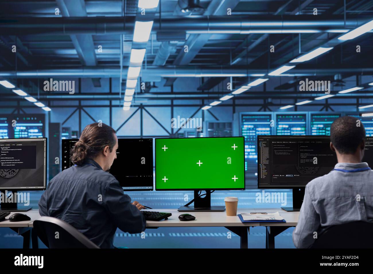 Colleagues working on green screen desktop PC in data center housing ...