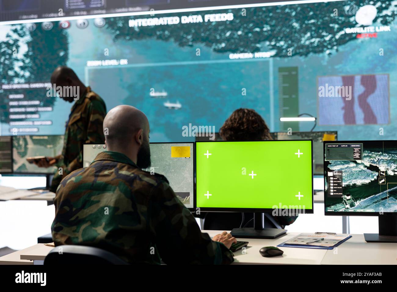 Recruit examining surveillance radar footage on monitor next to green ...