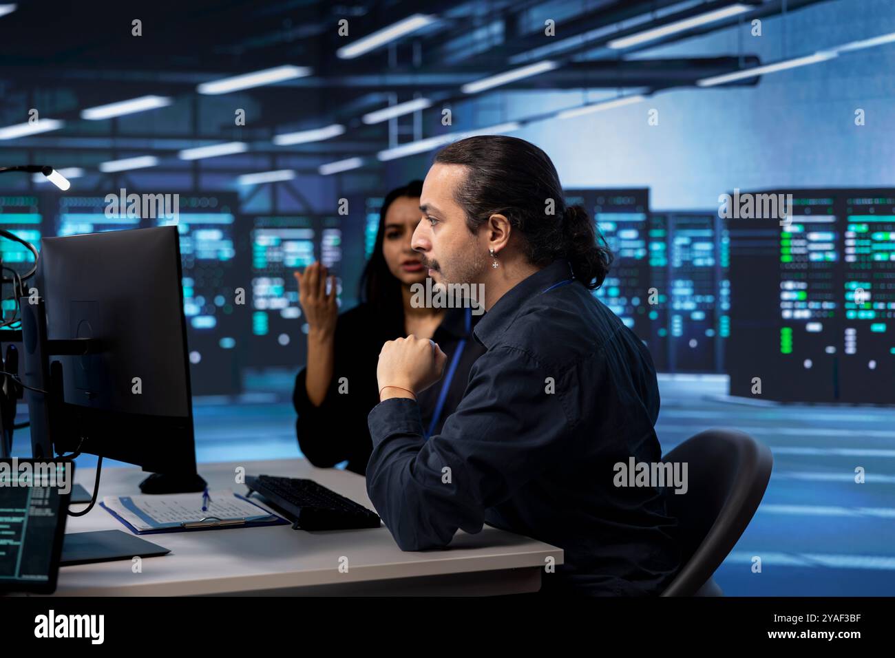 Technicians reconfiguring server room facility to optimize it for data processing requirements ...