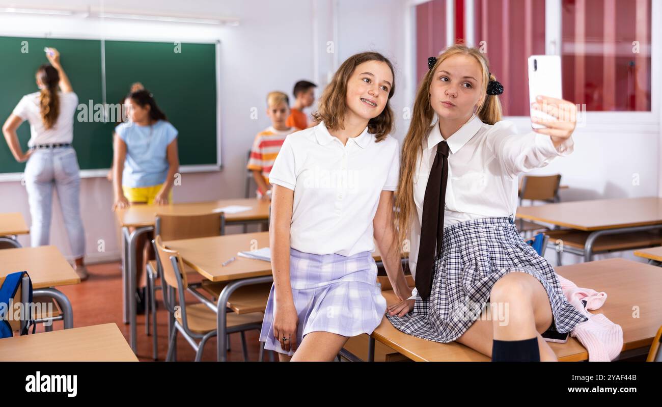 Two girls taking selfies in classroom during recess Stock Photo - Alamy