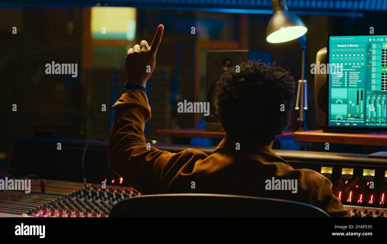 African american audio engineer counting down singer in sound booth ...