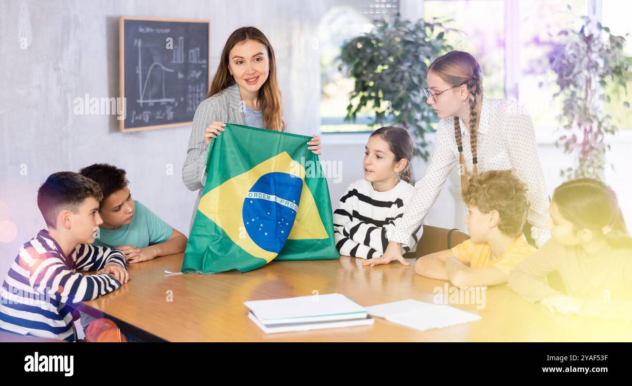 Teacher holds the flag of Brazil in her hands and tells the students ...
