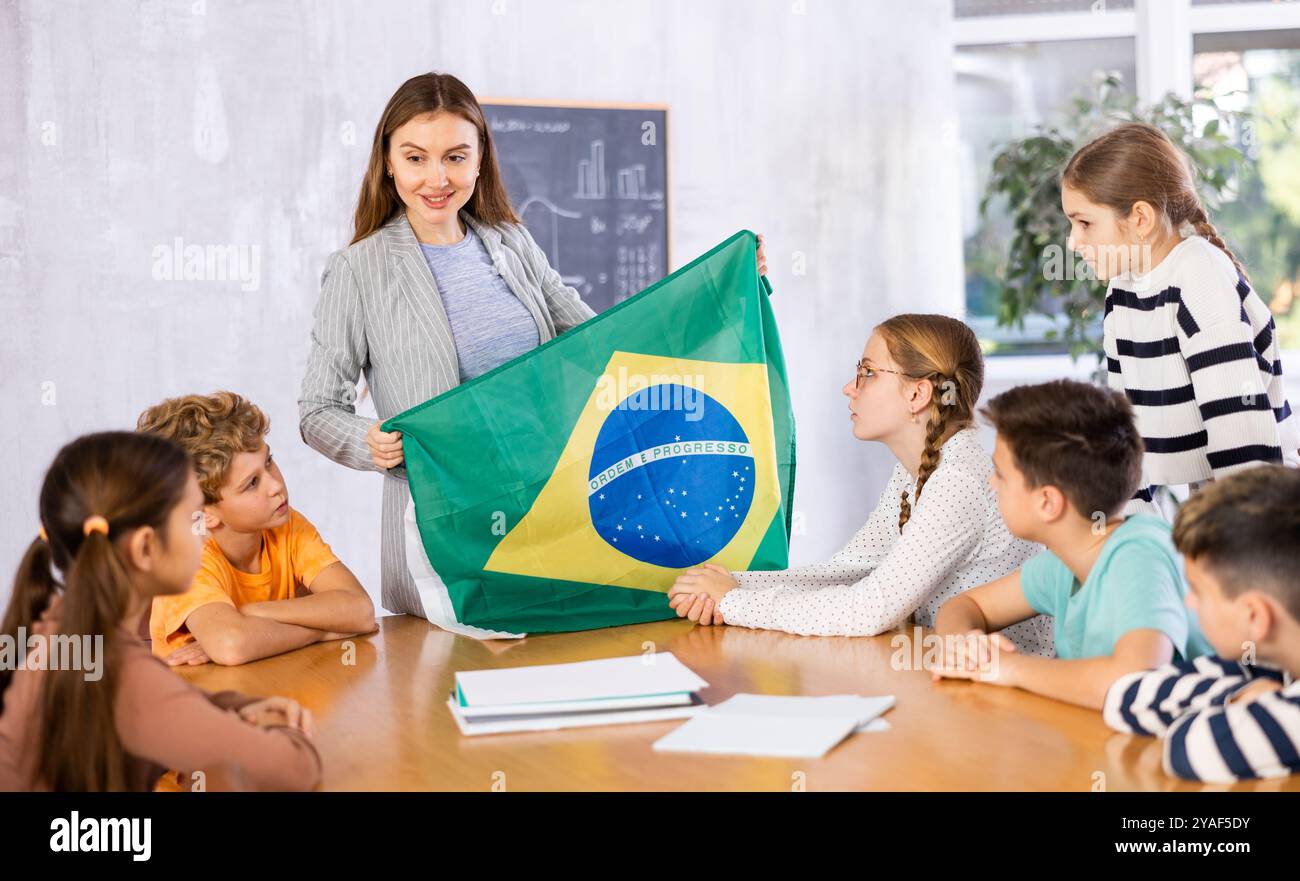 Teacher showing Brazil flag to group of schoolchildren Stock Photo - Alamy