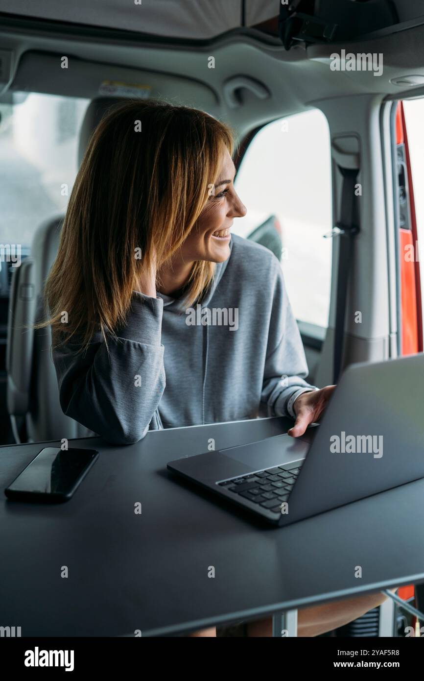 Blonde woman looking out van window Stock Photo - Alamy