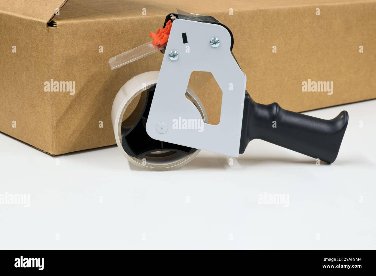 Tape gun dispenser and cardboard box shipping concept with copy space ...