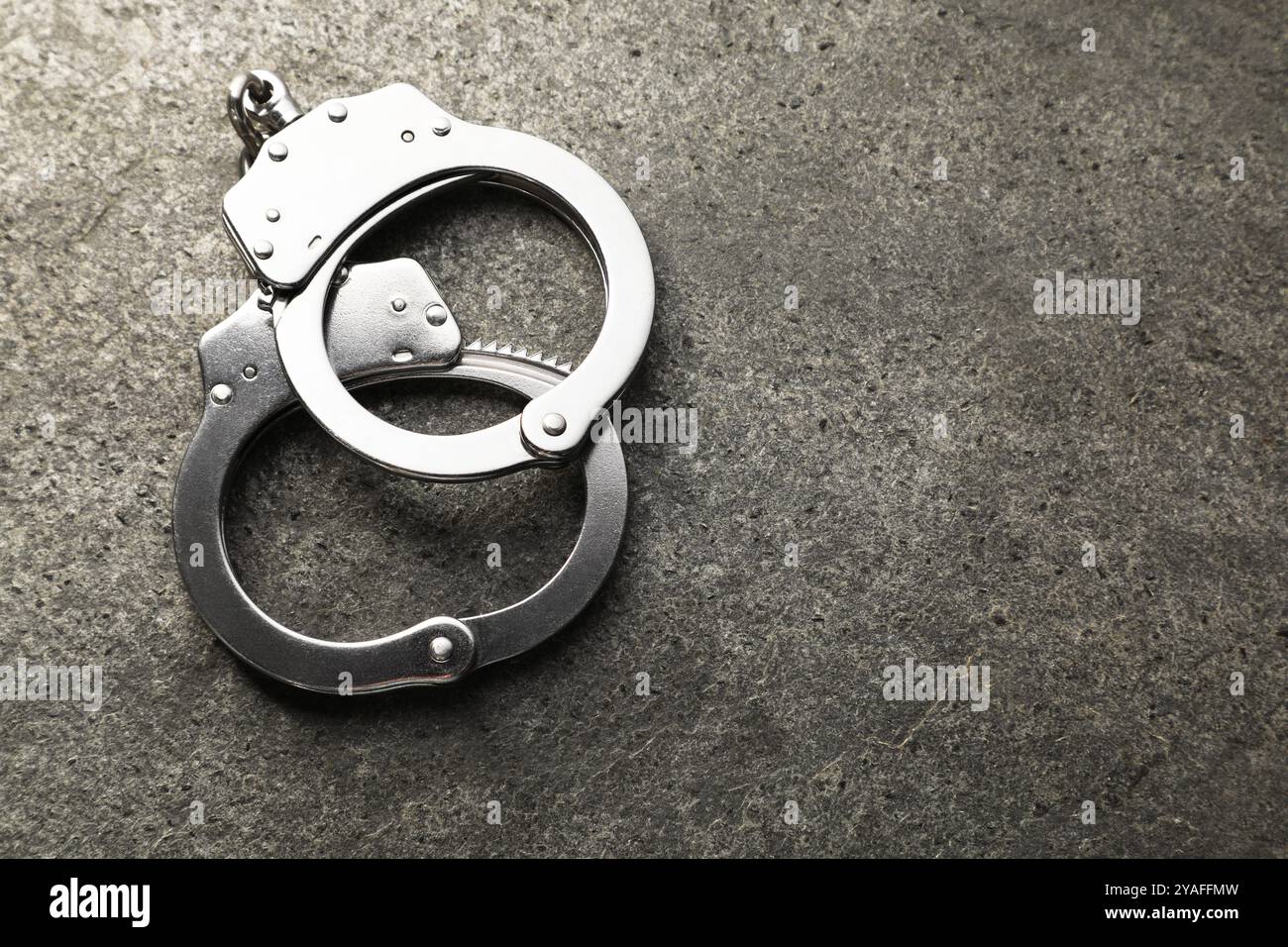 Classic chain handcuffs on grey table, top view. Space for text Stock ...