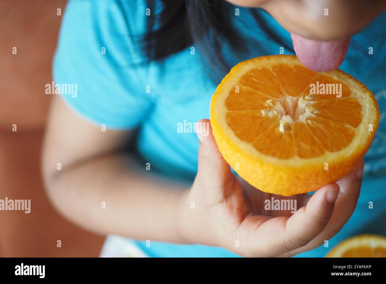 A Child Enjoys an Orange Slice with Delightful Anticipation and Joyful Excitement in the Moment ...