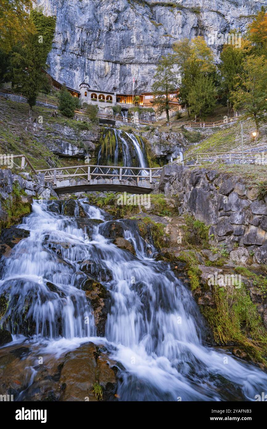 A waterfall flowing over rocks with a bridge in the foreground, St ...