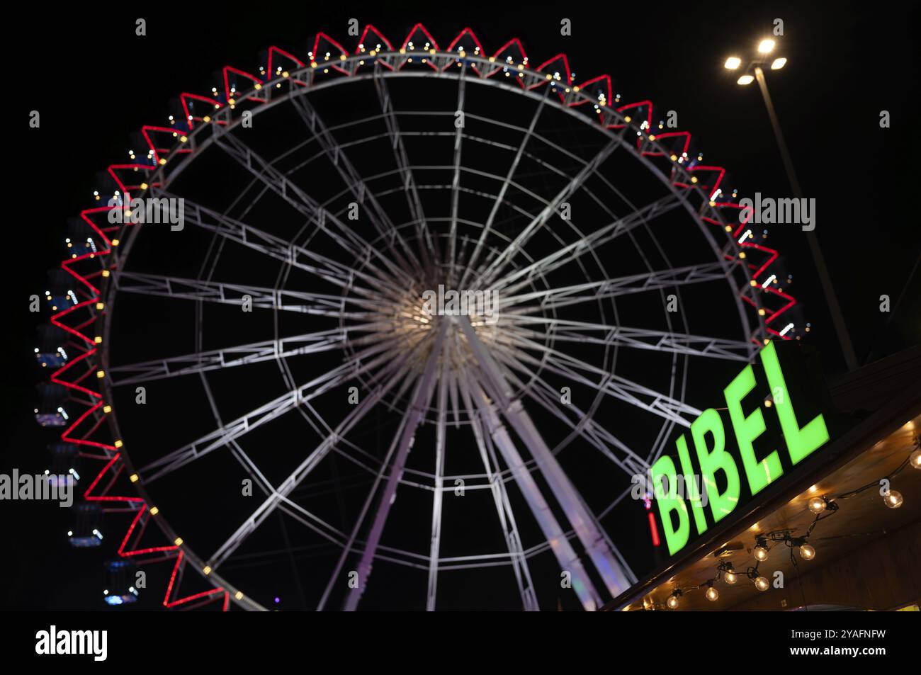 Night shot, sales stand for Bibles, religion, neon sign, Ferris wheel ...
