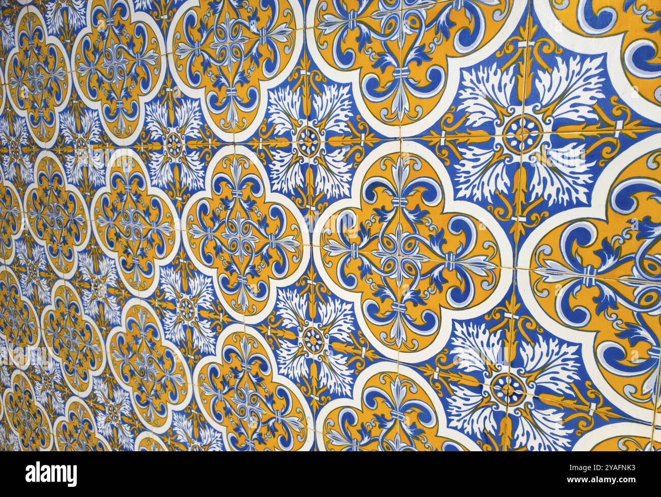 Decorative tiles with blue and yellow patterns on a wall, showing a ...