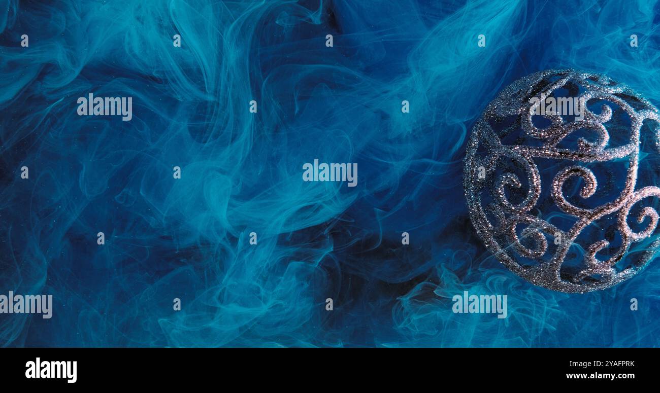 Christmas magic. Blue smoke background. Shiny intricate Xmas bauble ...
