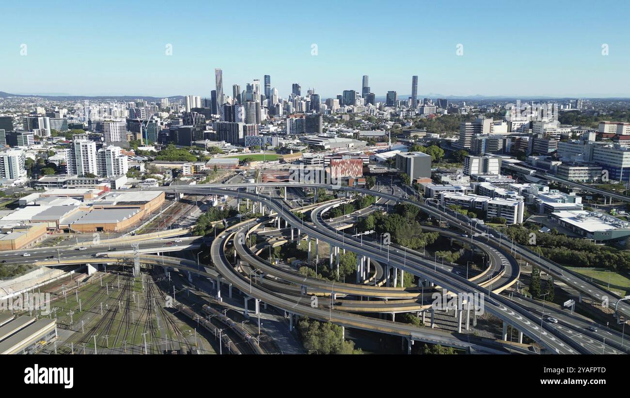 An aerial flyover of Bowen Hills Interchange with Brisbane skyline on a warm winter's day in ...