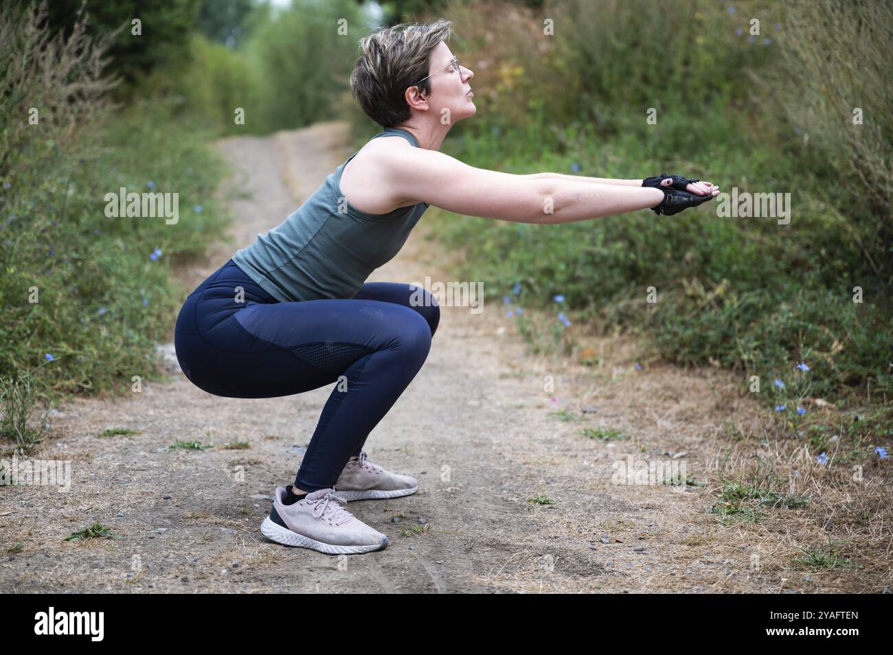 Active 36 year old white woman doing a squat outdoors, Brussels, Belgium, Europe Stock Photo - Alamy