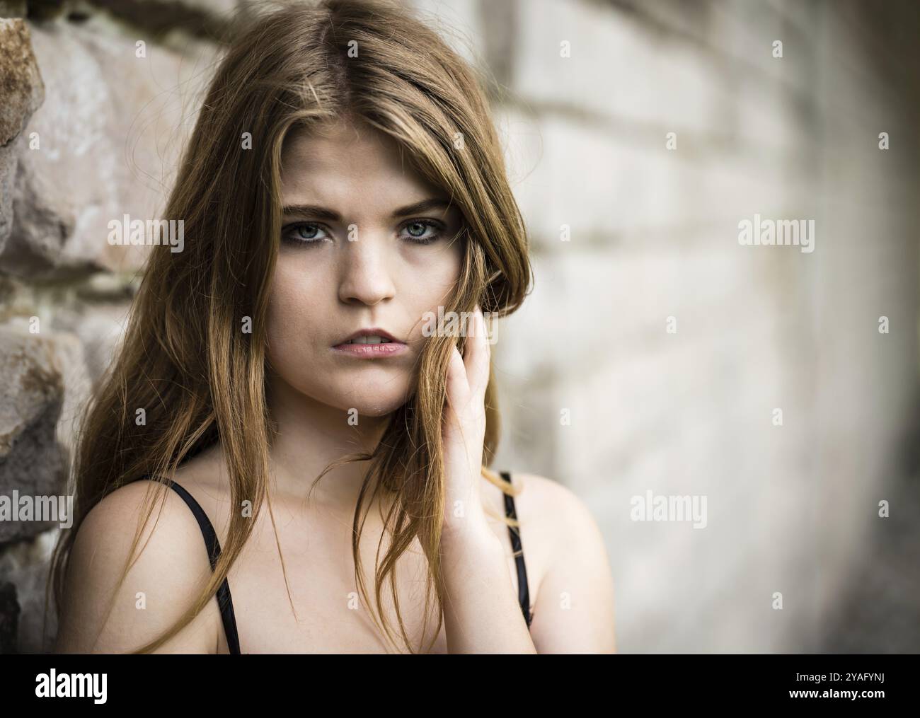 Close-up portrait of a pretty young white woman, standings against a ...