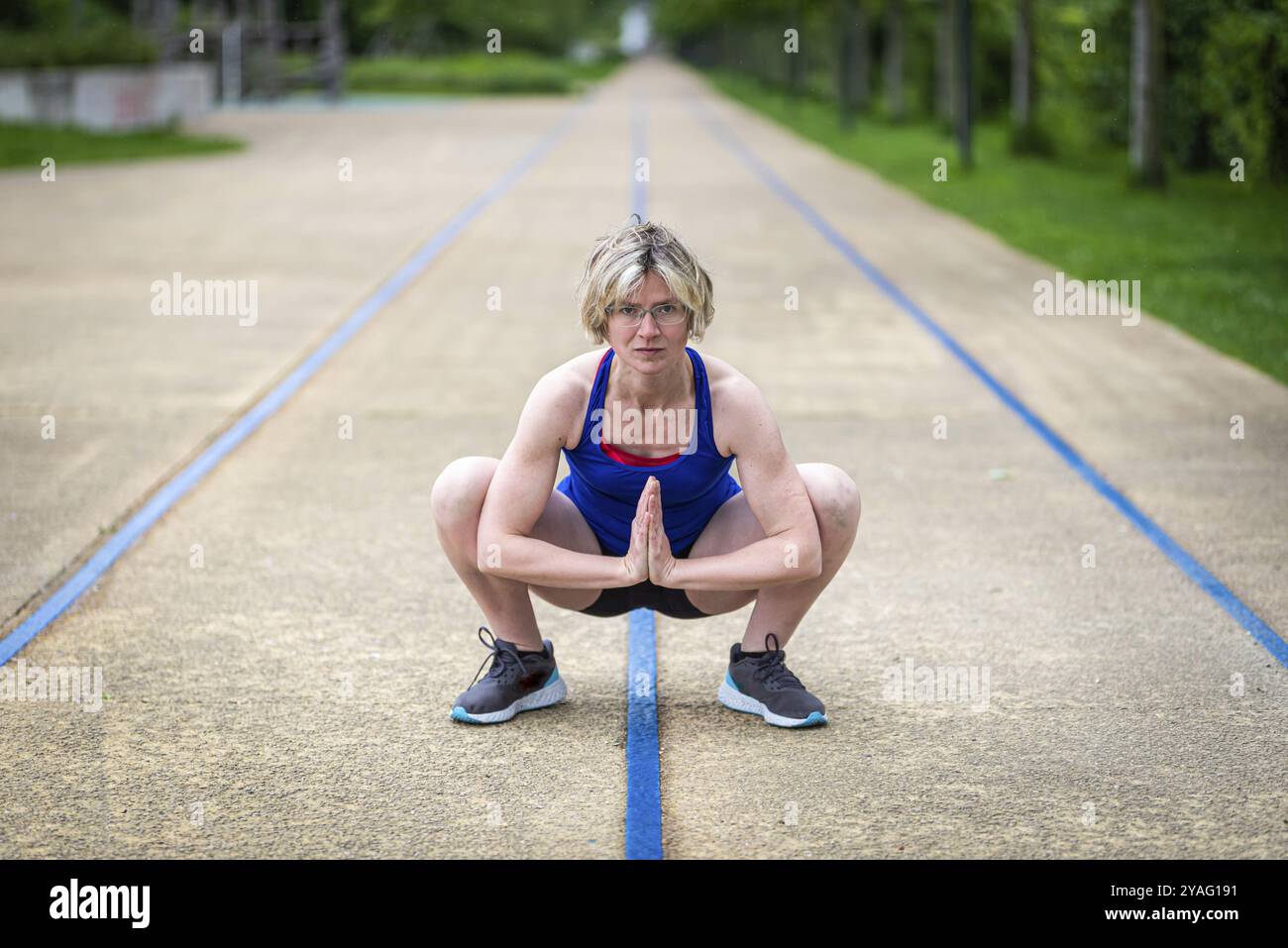 Woman stretching hips and adductors in a squat position, Belgium ...